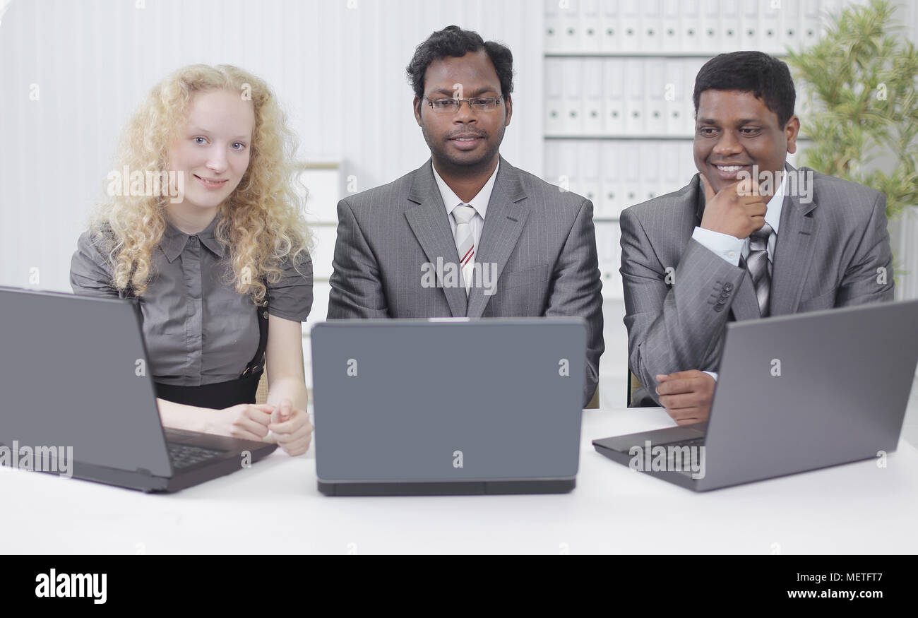 three employees sitting on the workplace in the office Stock Photo - Alamy