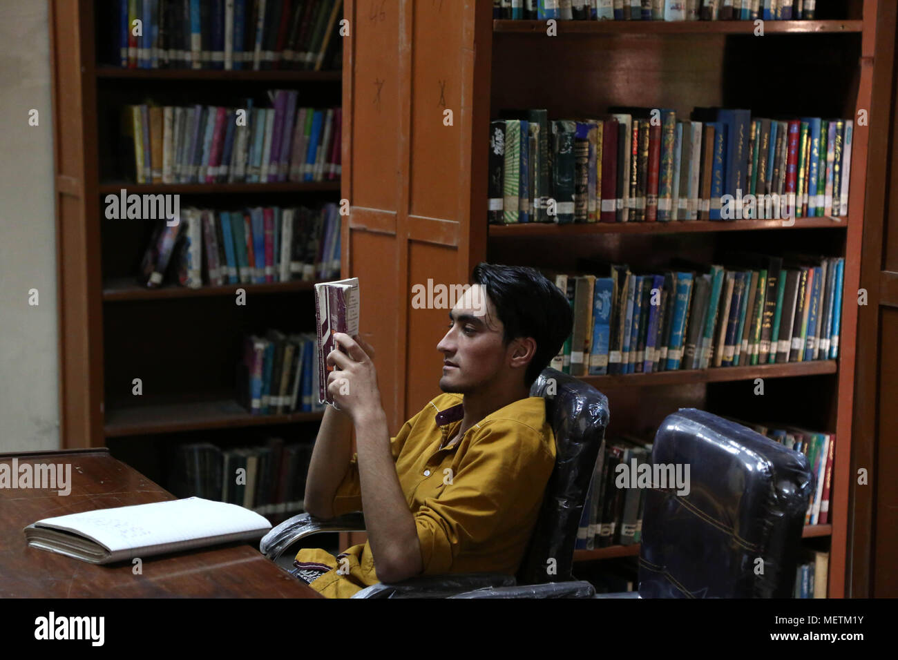 Islamabad, Pakistan. 23rd Apr, 2018. A Pakistani man reads at Islamabad ...