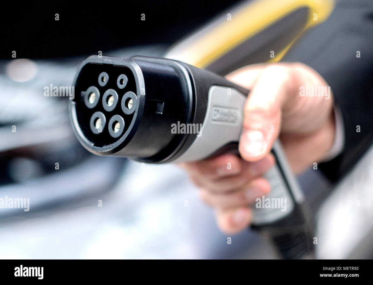 23 April 2018, Germany, Hannover: A fair visitor holding the plug of a ...