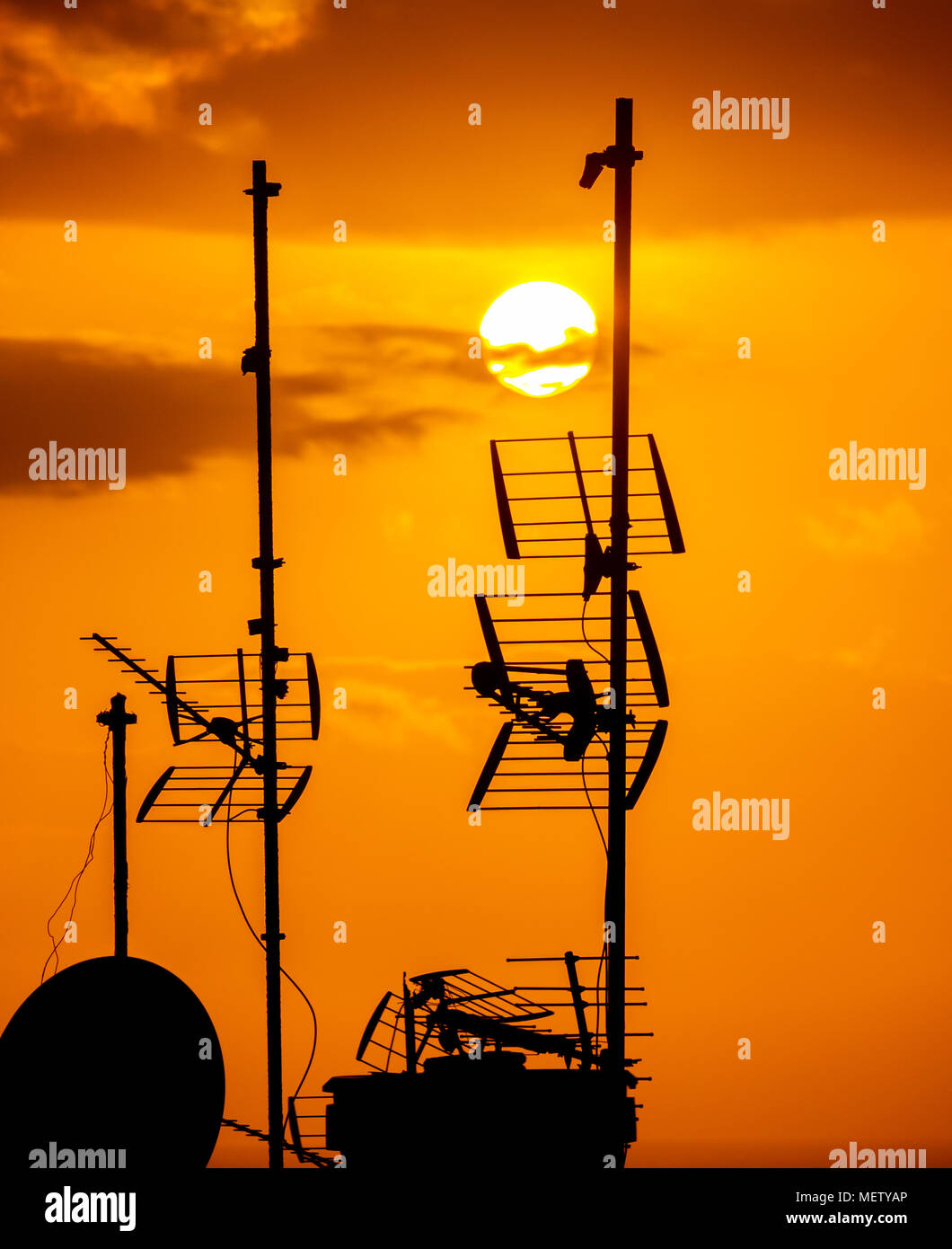 Sunset behind TV aerials Stock Photo - Alamy