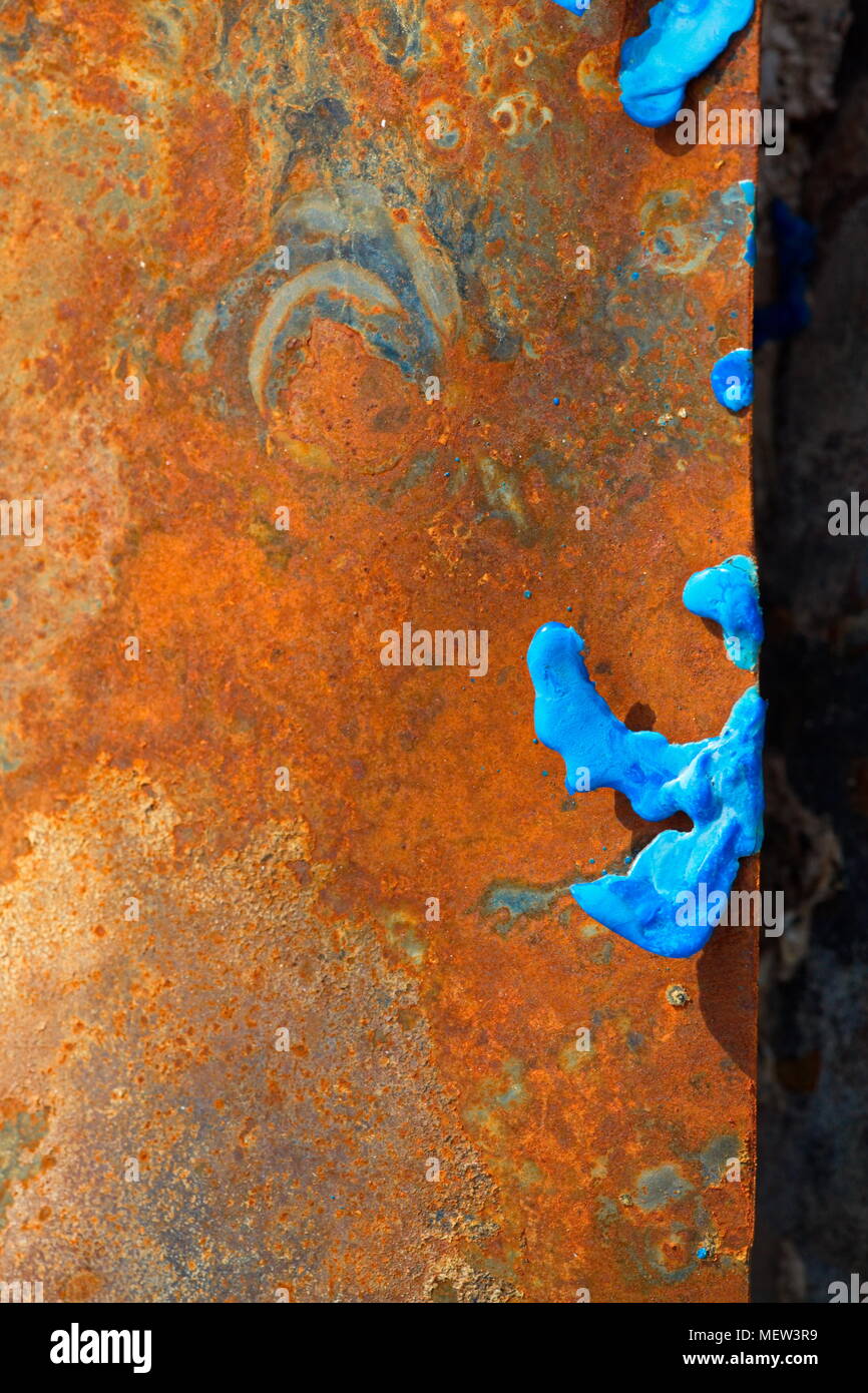 Blue melted plastic is covering rusty sheet metal on a burned up ...