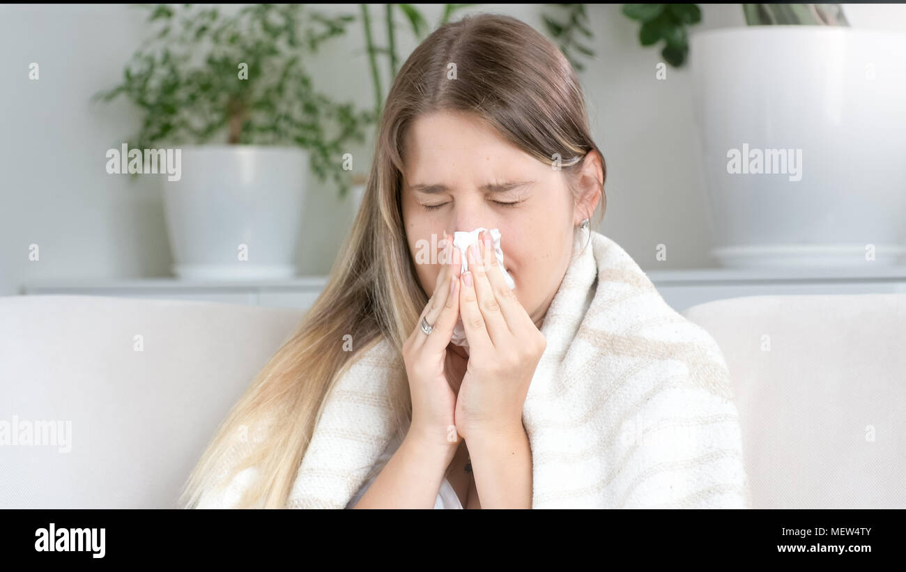 Portrait of young woman with cold using paper tissues Stock Photo - Alamy