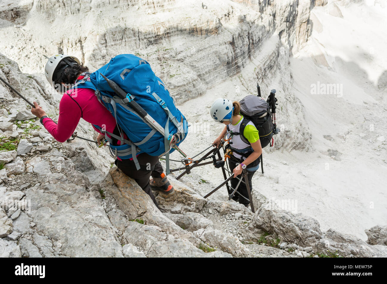 Climbers tackling via ferrata metalic ladder Stock Photo - Alamy