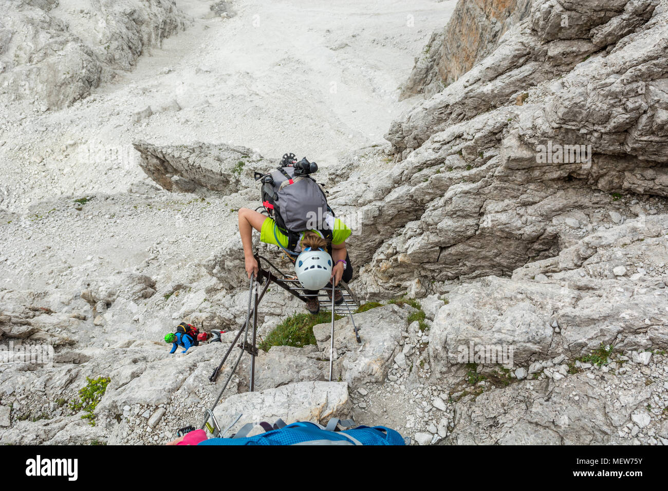 Climbers tackling via ferrata metalic ladder Stock Photo - Alamy
