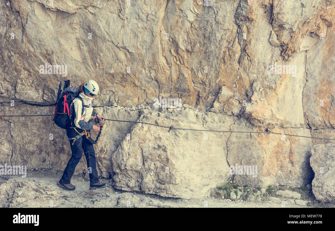 Climber walking on narrow ledge protected by via ferrata set Stock ...