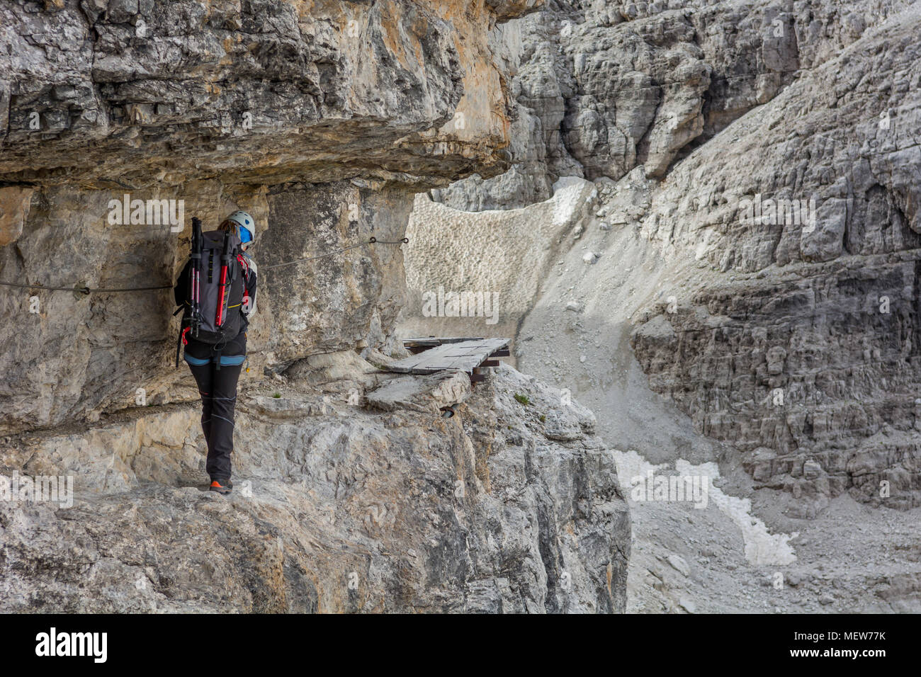 Climber walking on narrow ledge protected by via ferrata set Stock ...