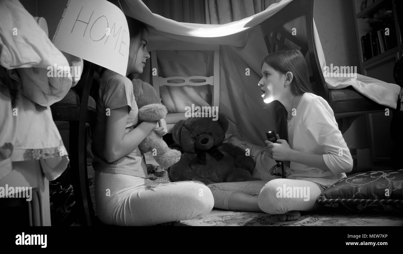 Black and white photo of two girls telling scary stories with ...