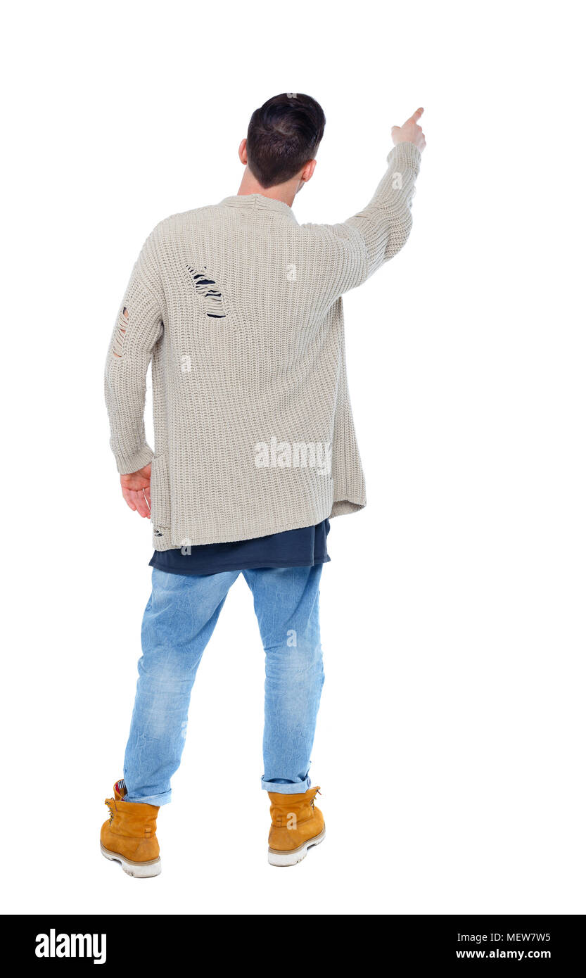 Back view of a stylish man in a knitted sweater points his hand upwards ...