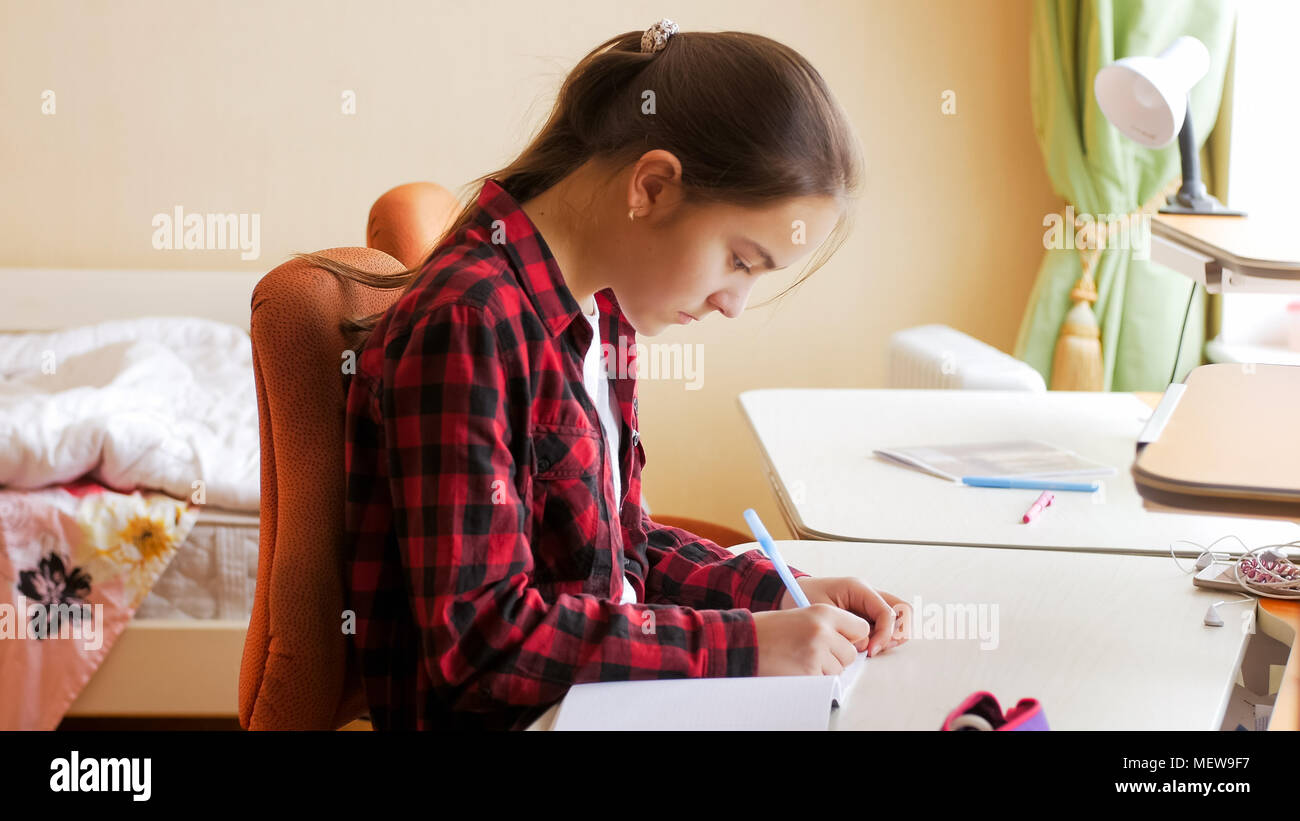 Portrait of concentrated girl doing homework in bedroom Stock Photo - Alamy