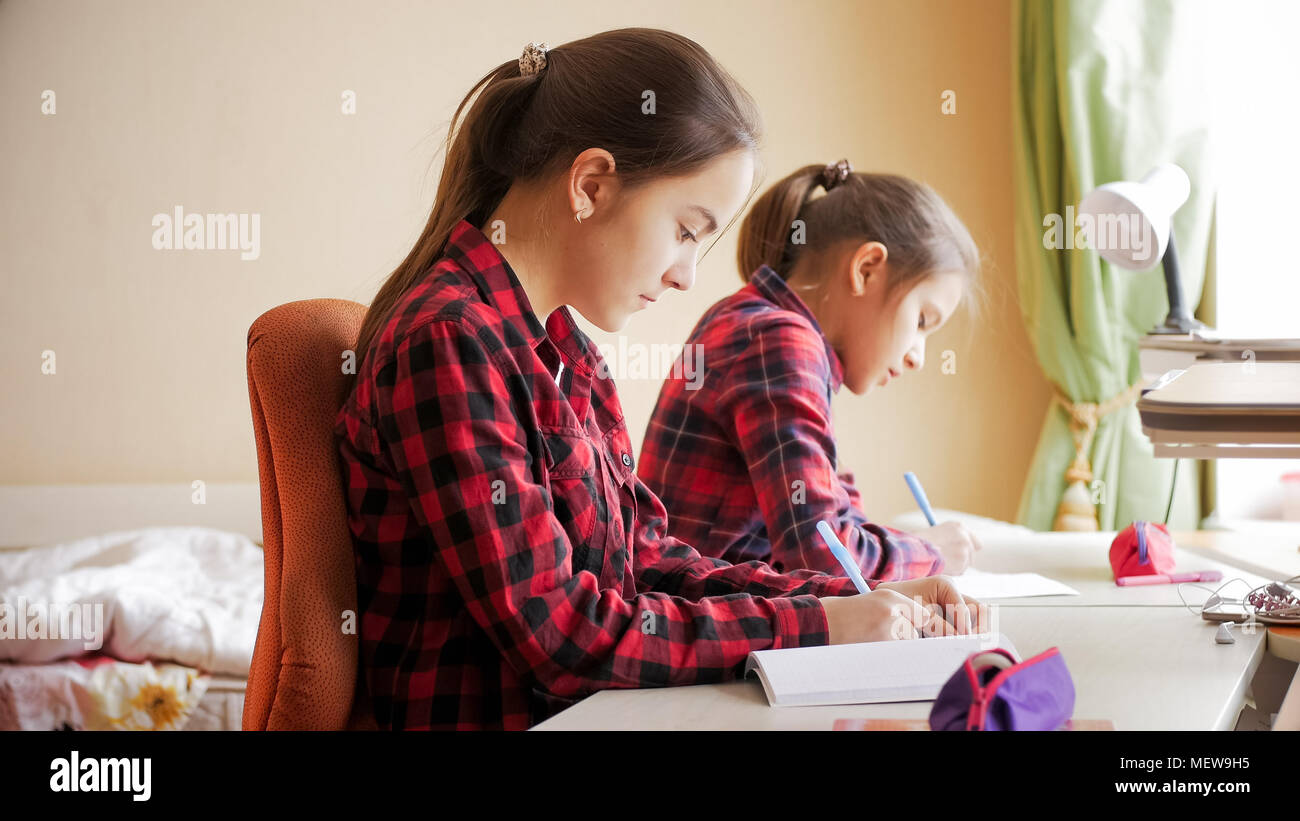 Portrait of teenage girls writing in copybooks Stock Photo - Alamy