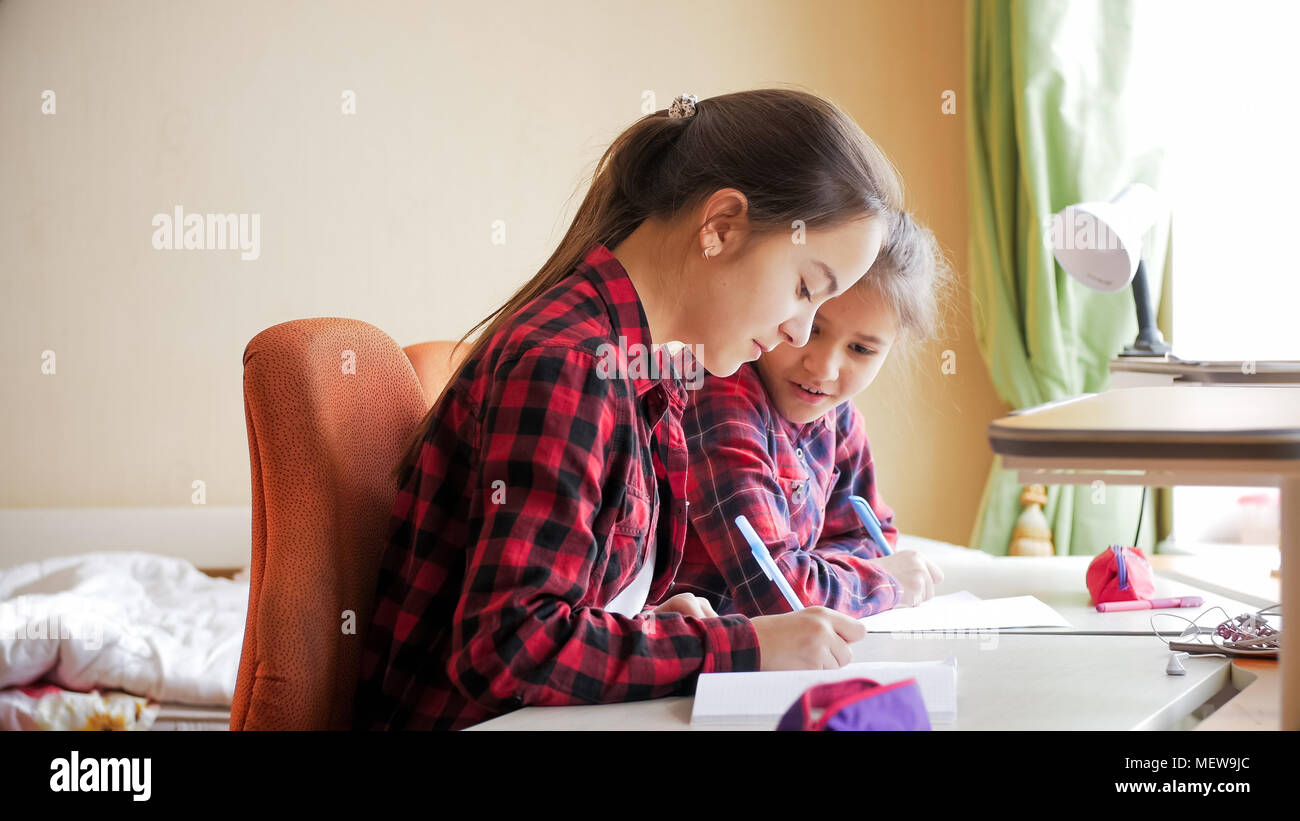 Two teenage girls talking and doing homework at dig window Stock Photo ...