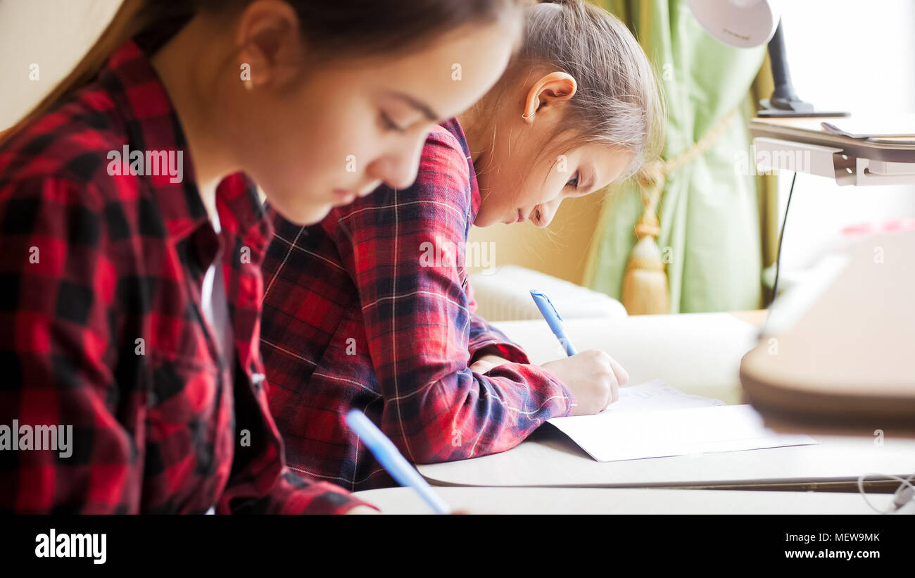 Closeup portrait of concentrated girl writing homework Stock Photo - Alamy