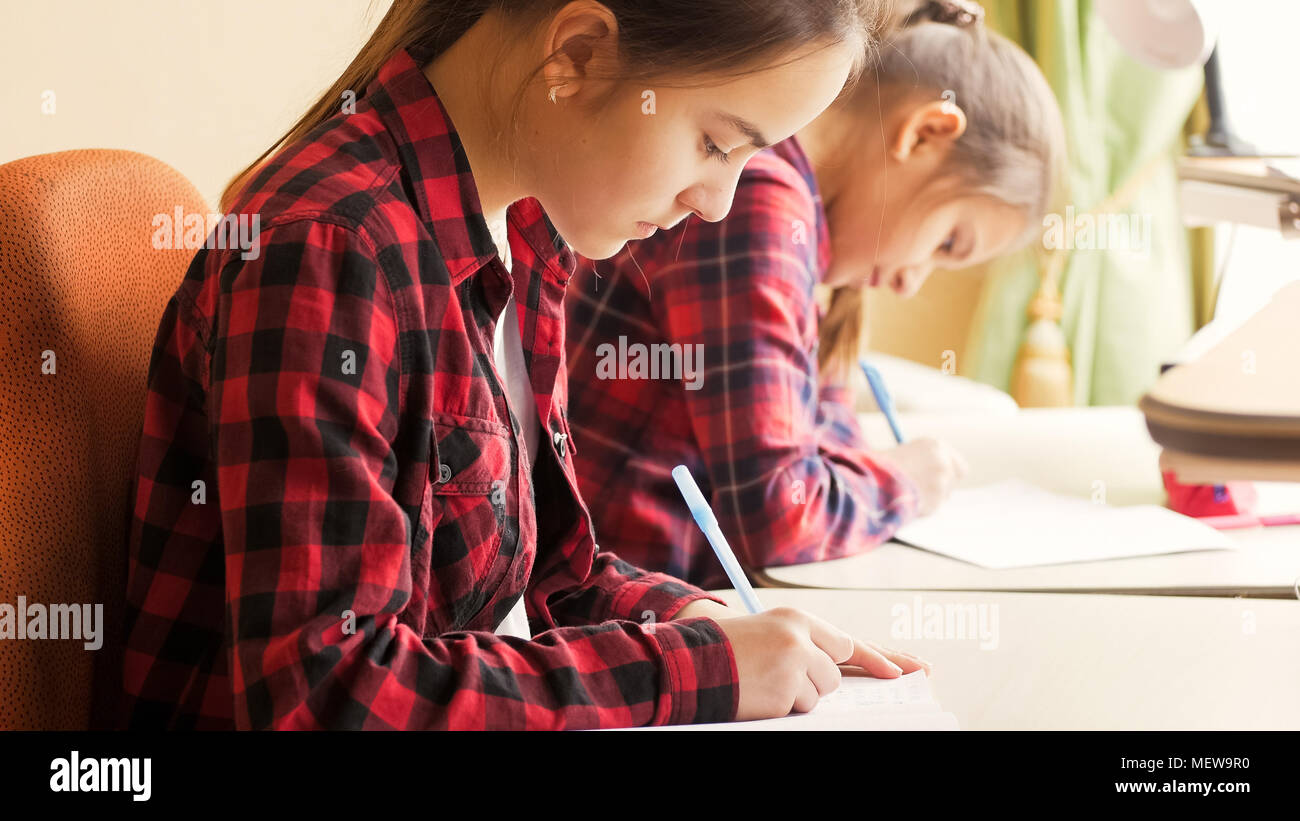 Two twin sisters doing homework behind big desk at bedroom Stock Photo ...