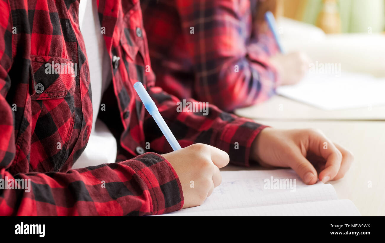Closeup shot of two sisters writing homework with pens Stock Photo - Alamy