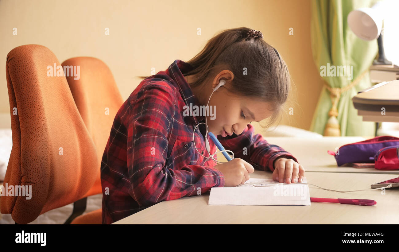 Toned photo of teenage girl listening to music and singing while doing ...