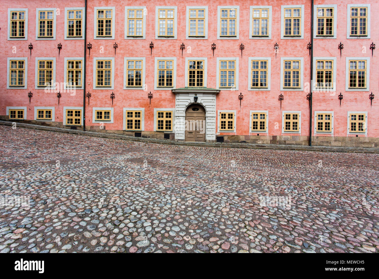 Pink building and cobblestoned road Stock Photo - Alamy
