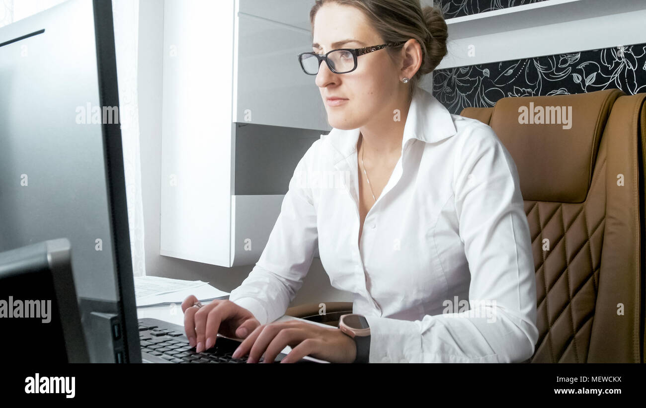 Beautiful secretary in eyeglasses wotking on computer at office Stock ...