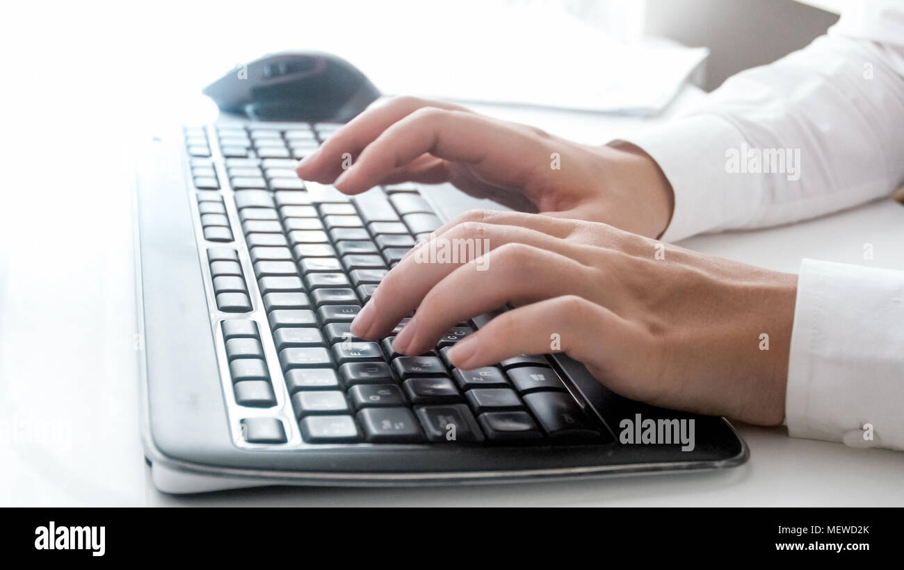 Closeup image of beautiful female hands working on computer keyboard ...