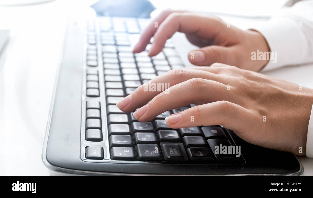 Closeup photo of young woman typing text on computer keyboard at office ...