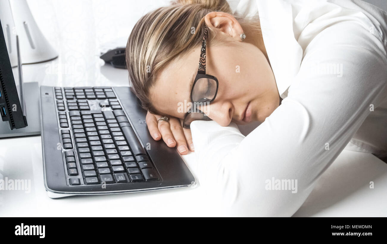 Closeup portrait of tired businesswoman lying on computer keyboard at ...