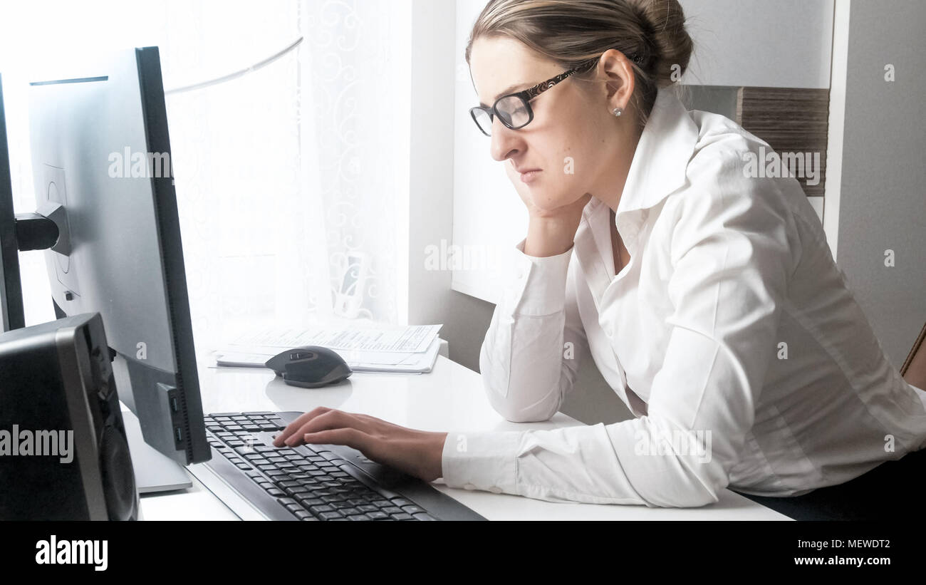 Sleepy female office worker sitting at big window Stock Photo - Alamy