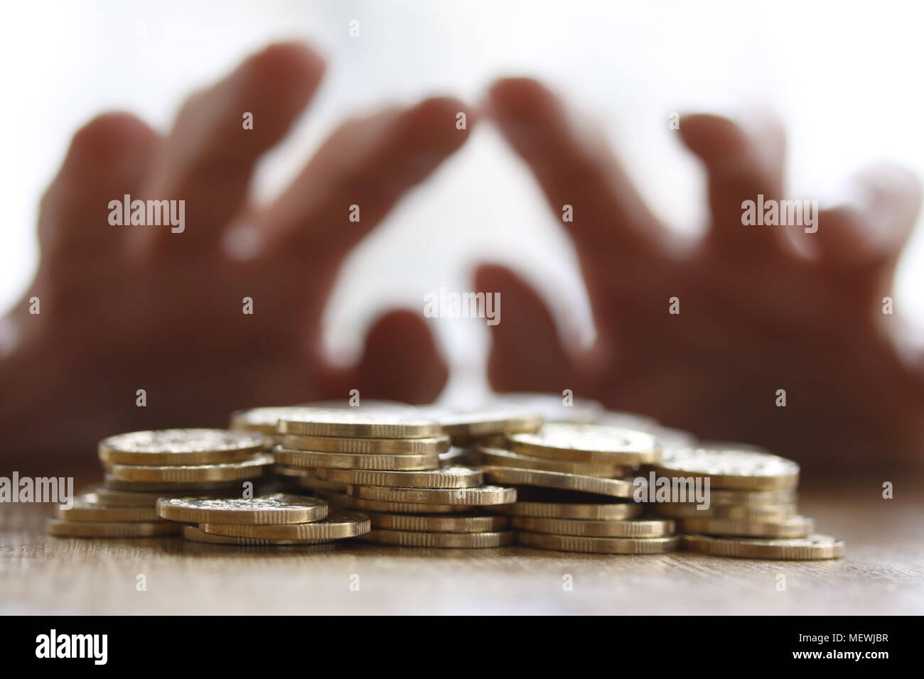 Love of money - Greedy hand grabbing or reaching out for pile of golden ...
