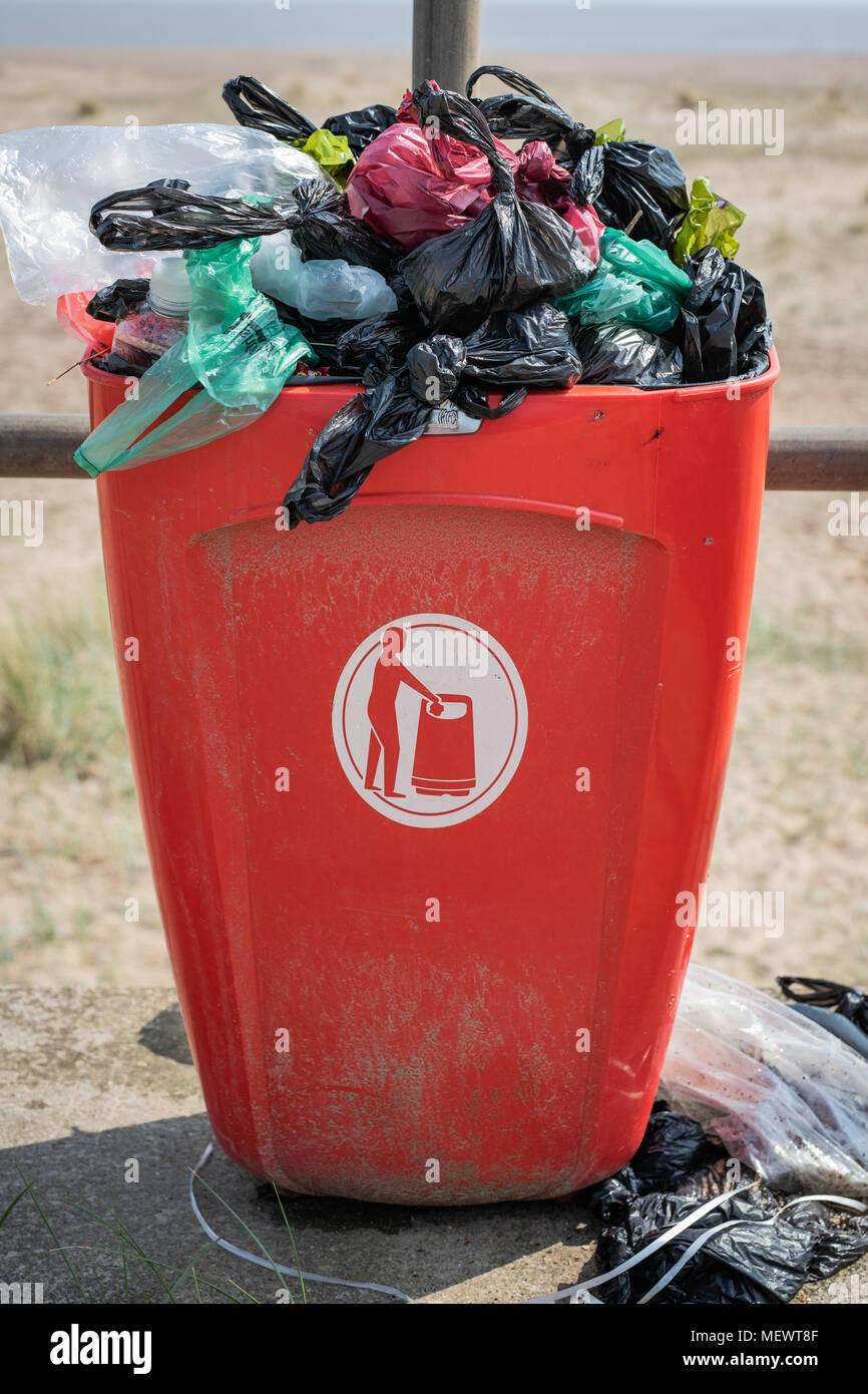 Bin overflowing on beach front Stock Photo - Alamy
