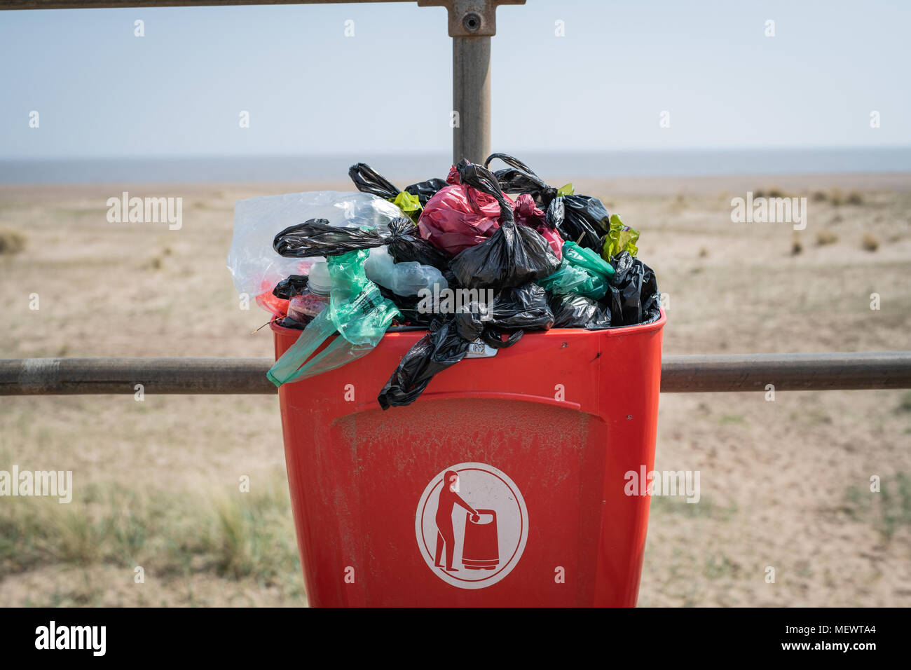 Bin overflowing on beach front Stock Photo - Alamy