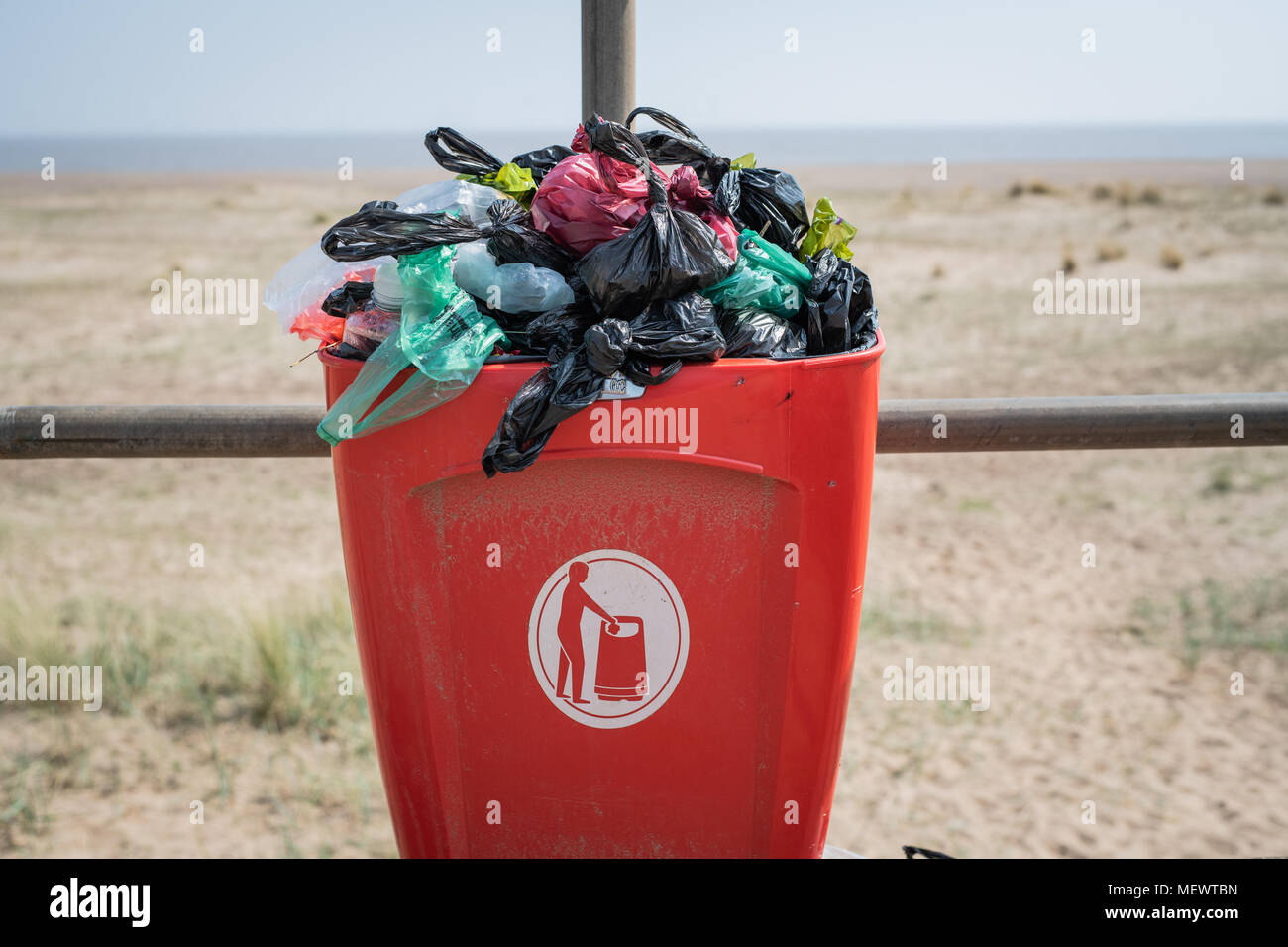 Bin overflowing on beach front Stock Photo - Alamy