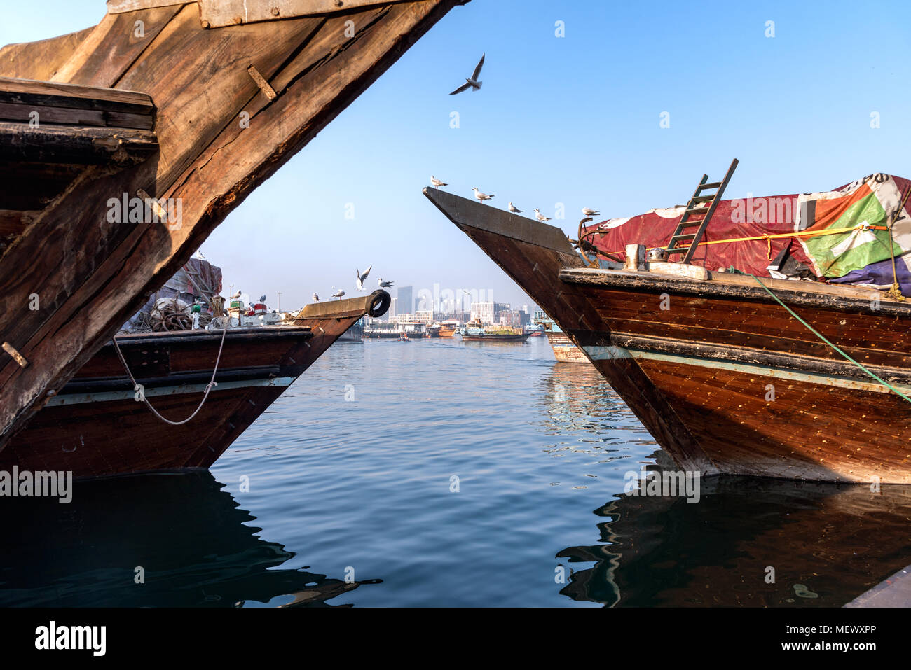 Traditional wooden dhow cruise across the Creek with a view of skyline ...