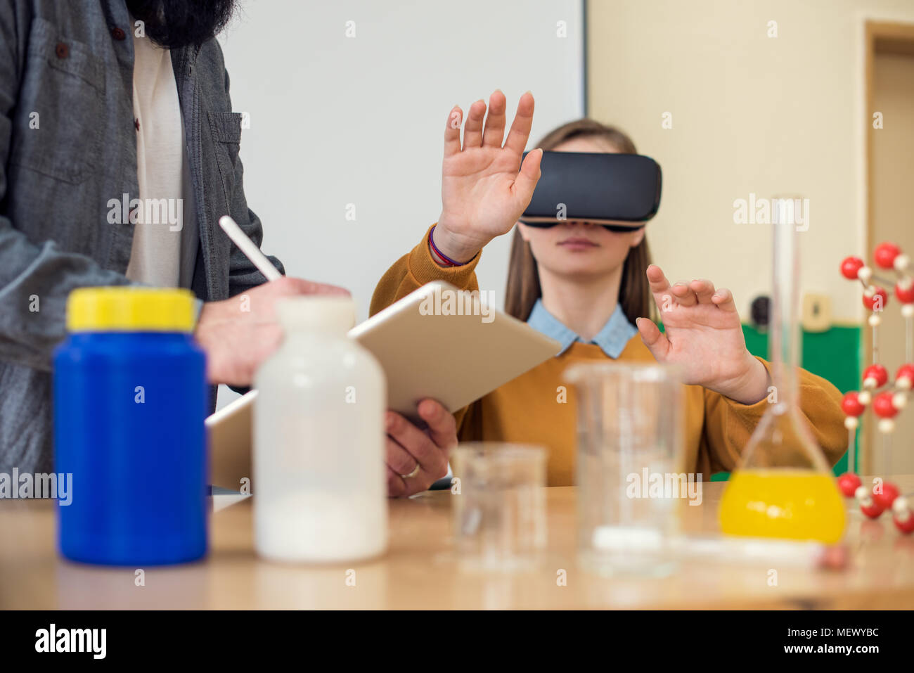 Young teacher using Virtual Reality Glasses and 3D presentation to ...