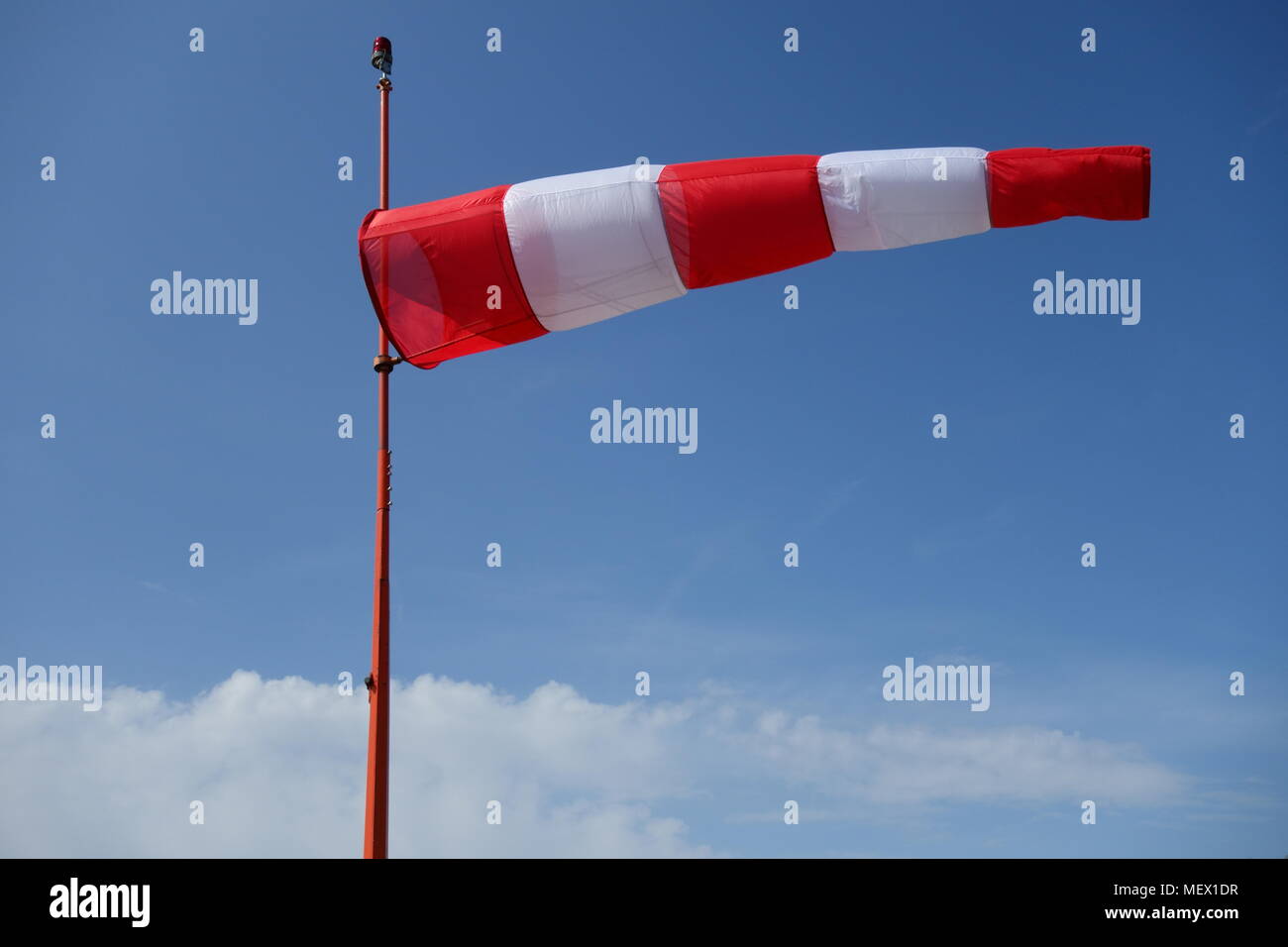 Red & white airfield windsock against a blue sky Stock Photo - Alamy