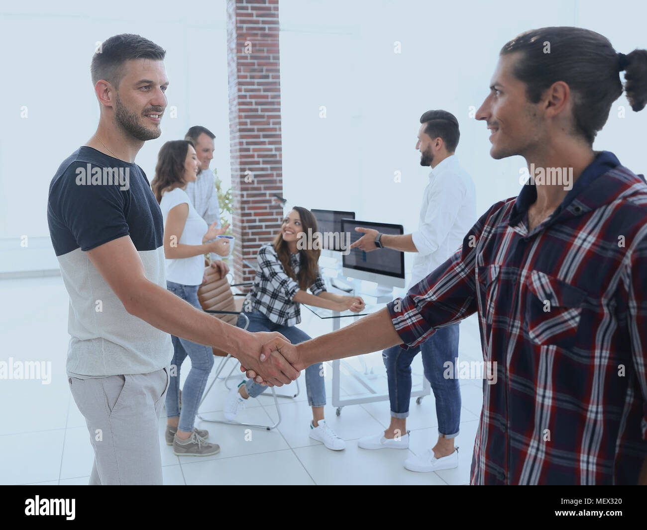 handshake colleagues in creative office Stock Photo - Alamy