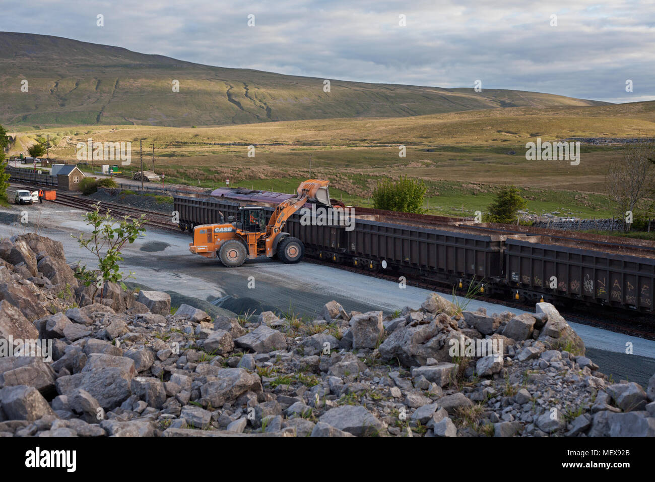 DB Cargo aggregates train being loaded with gritstone in the sidings ...