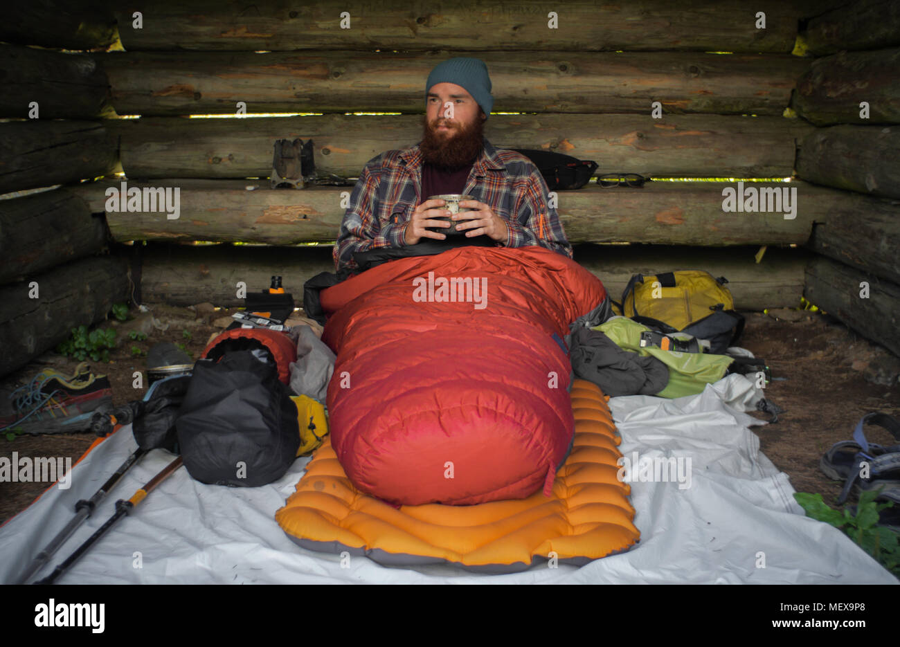 portrait of a caucasian male hiker laying on the ground in his sleeping ...