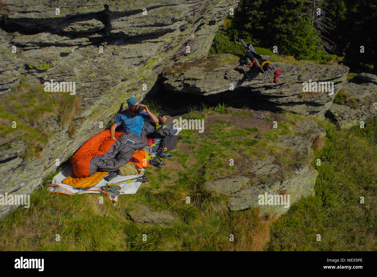 portrait of a caucasian male hiker laying on the ground in his sleeping ...