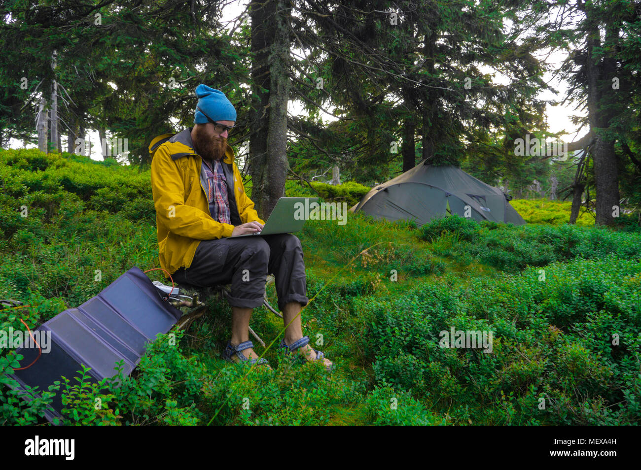 digital nomad, young caucasian man working on his laptop sitting on a ...