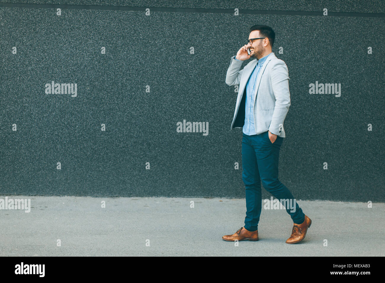 Young man walking and talking over the mobile phone outdoor Stock Photo ...