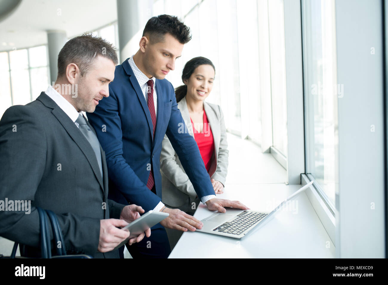 Confident colleagues thinking of company development Stock Photo - Alamy