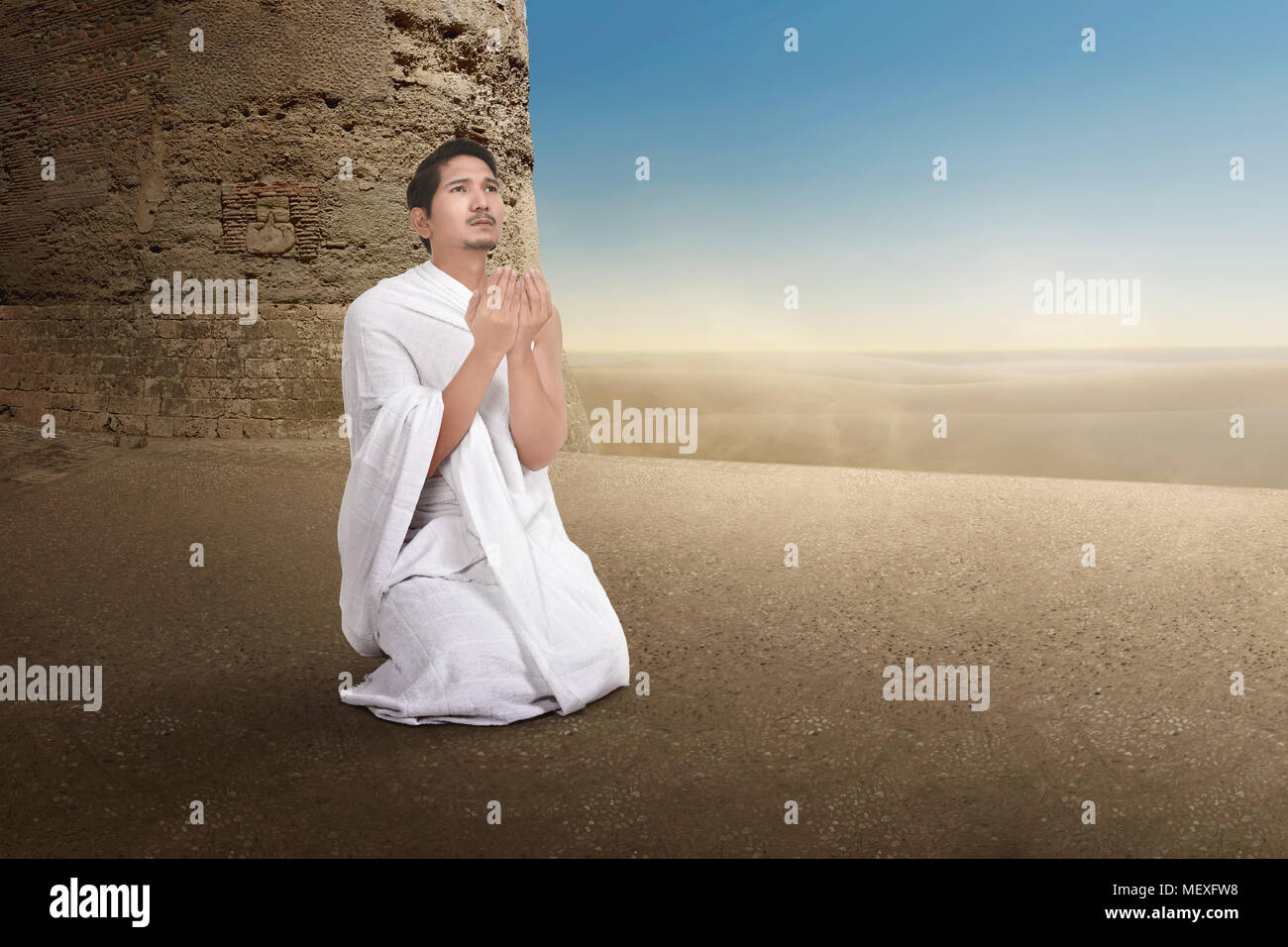 Handsome asian pilgrim kneeling and praying outdoor Stock Photo - Alamy