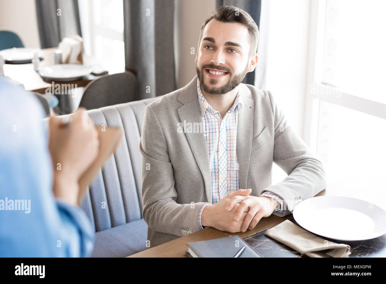 Cheerful businessman making order in restaurant Stock Photo - Alamy