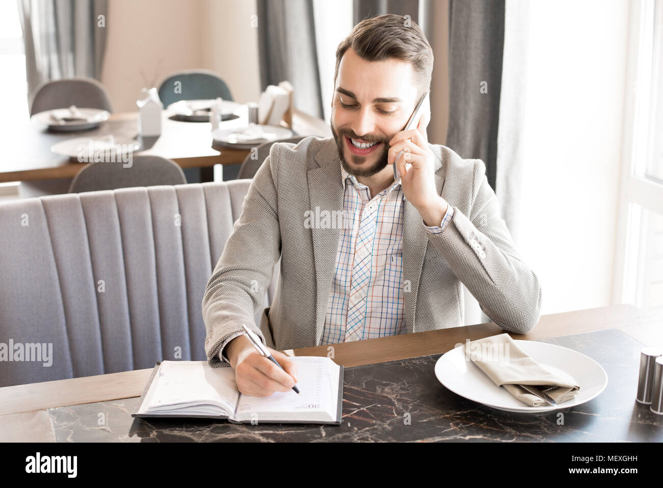 Cheerful businessman working in cafe Stock Photo - Alamy