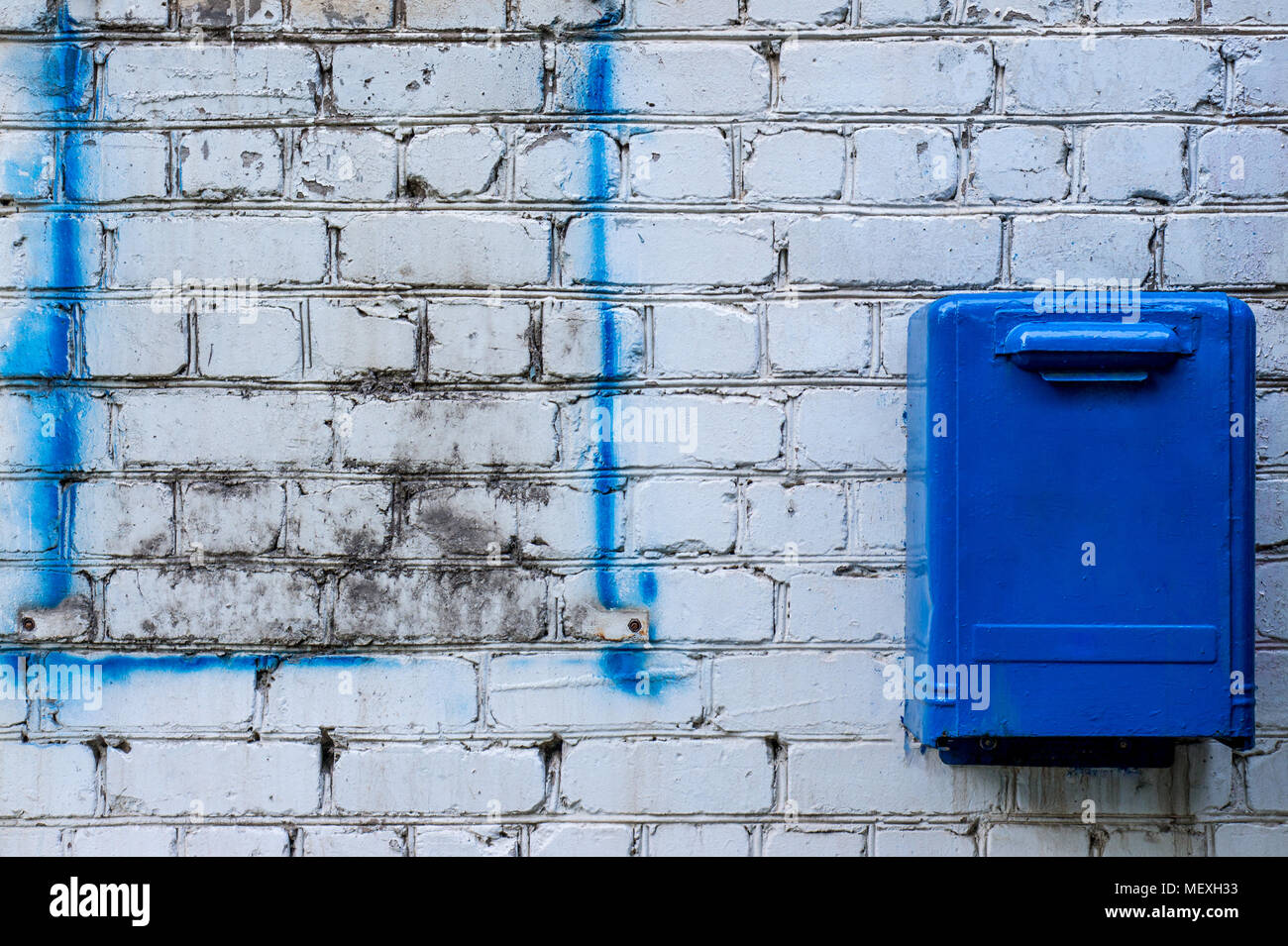 Blue mailbox on the white brick background Stock Photo - Alamy