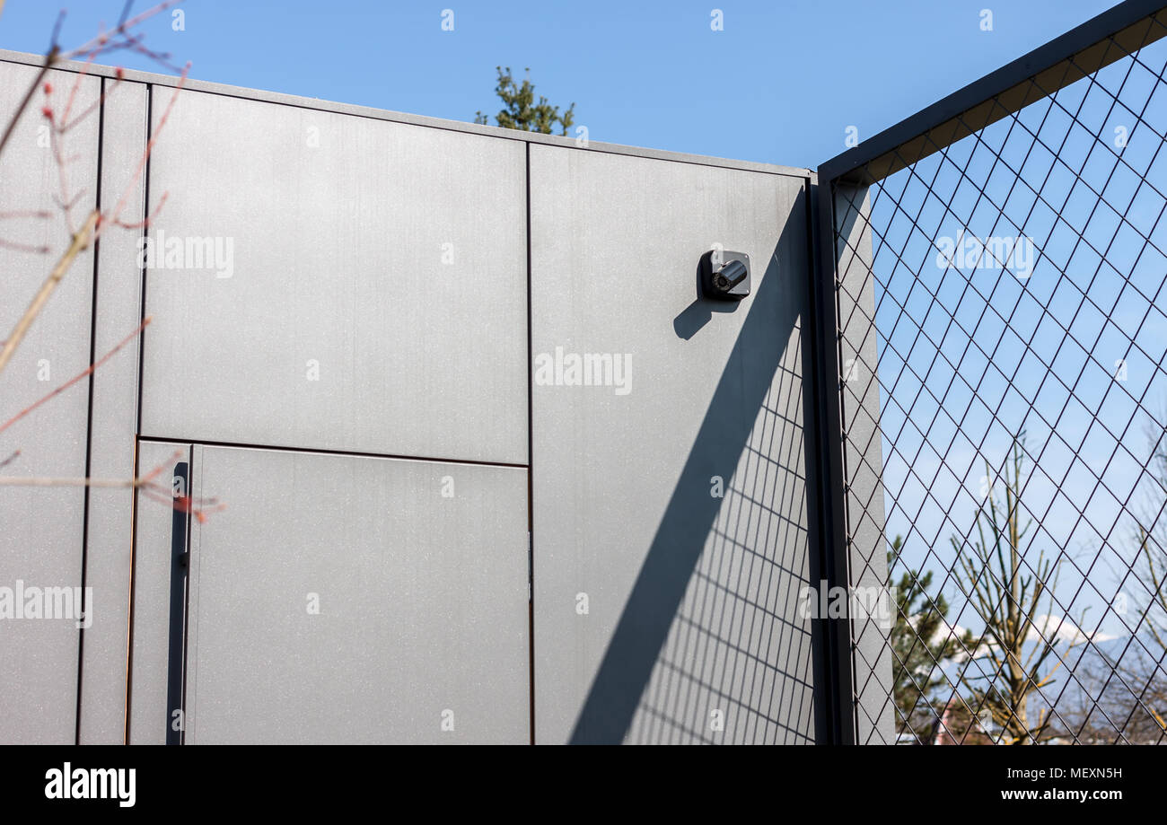cctv security system camera on black metal wall Stock Photo - Alamy