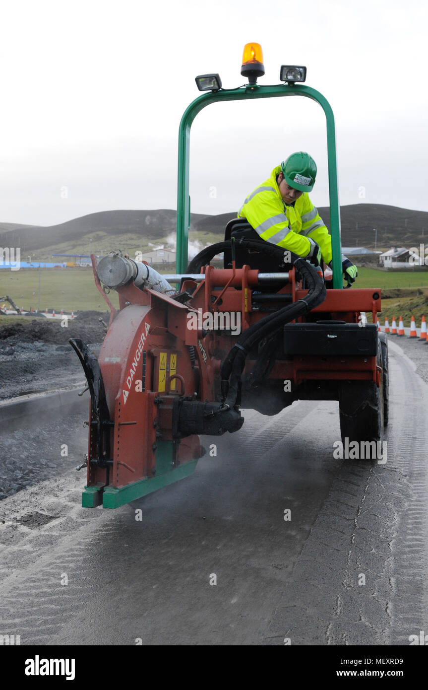 Track being cut in road by a saw so broadband cable can be laid Stock ...