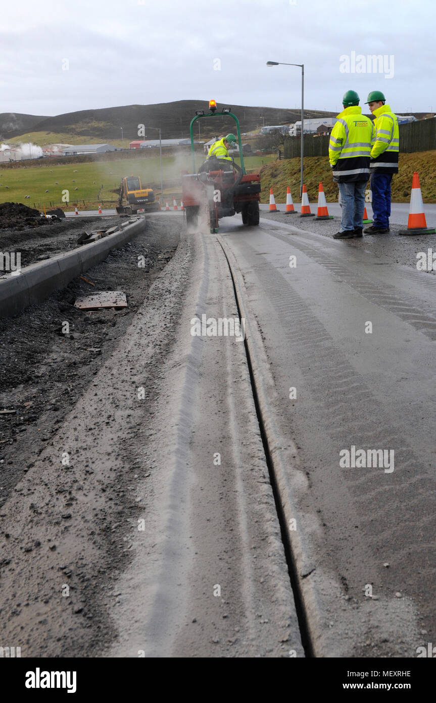 Track being cut in road by a saw so broadband cable can be laid Stock ...