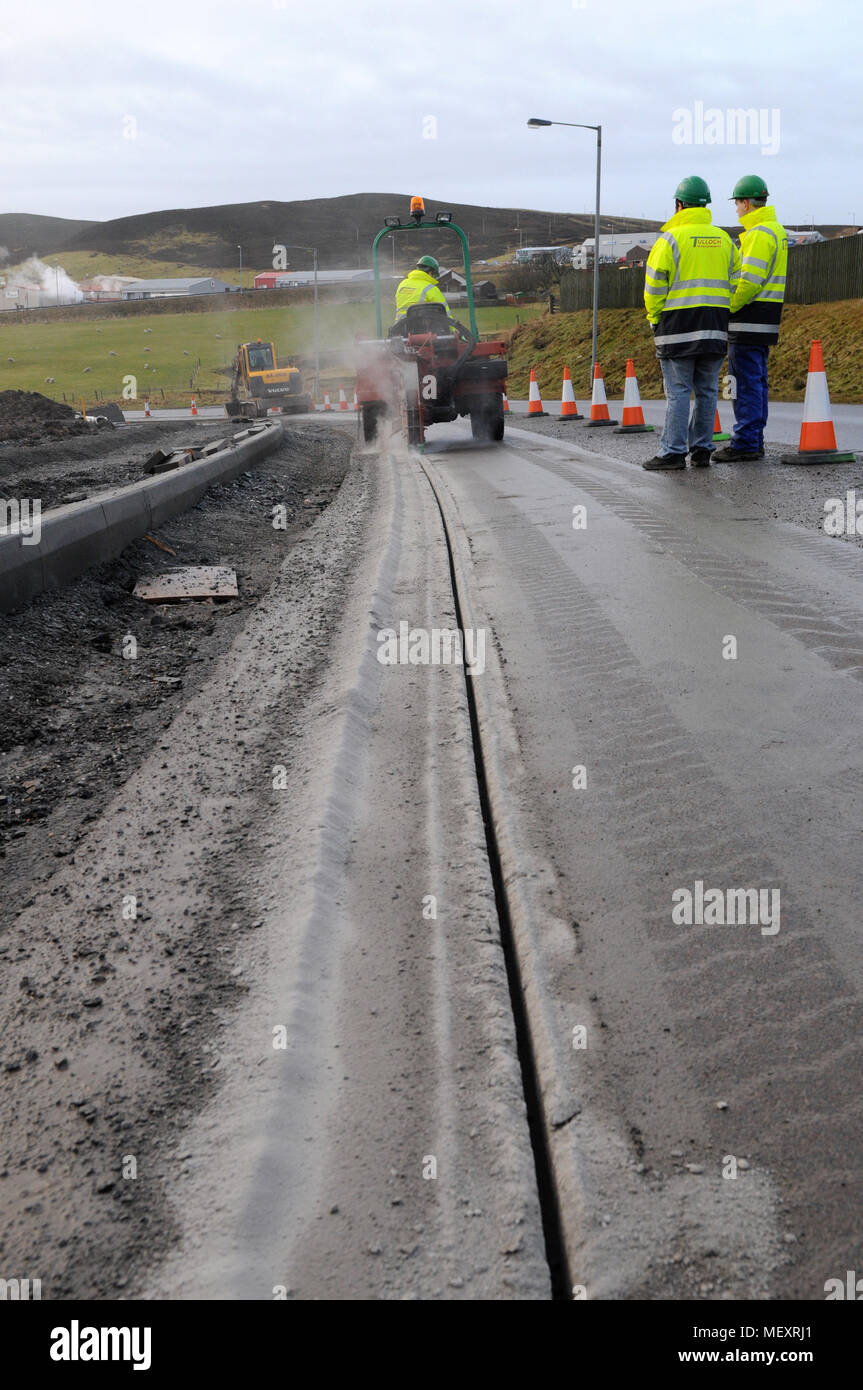 Track being cut in road by a saw so broadband cable can be laid Stock ...