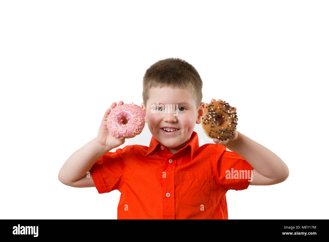 Little happy cute boy is eating donut on whte background wall. child is ...