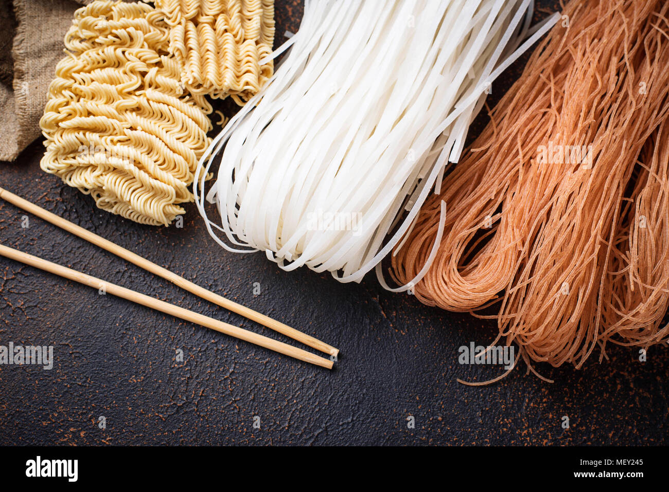 Different Asian rice noodles on rusty background Stock Photo - Alamy