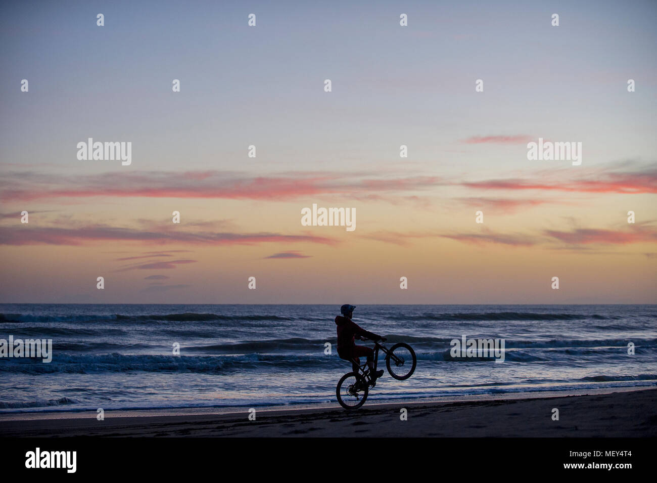 A mountain biker rides along a beach near the port town of Punta Ala in ...